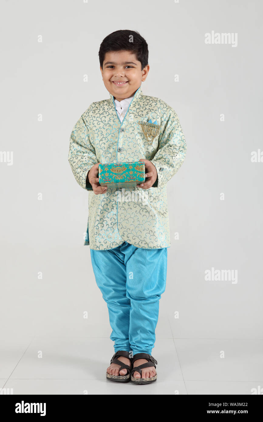 Boy holding a gift box and smiling Stock Photo - Alamy