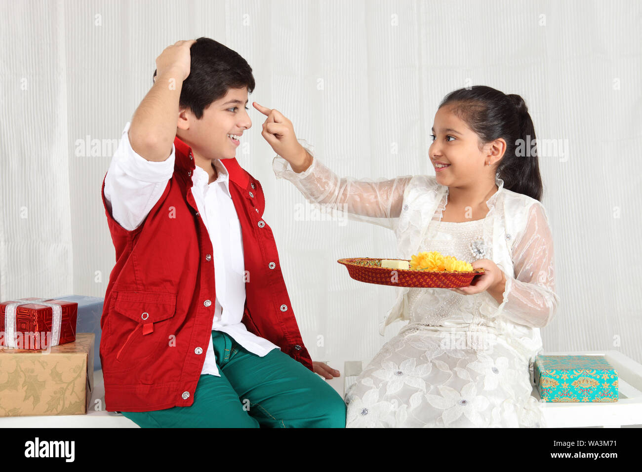 Girl applying tika on her brother forehead at Raksha Bandhan festival ...