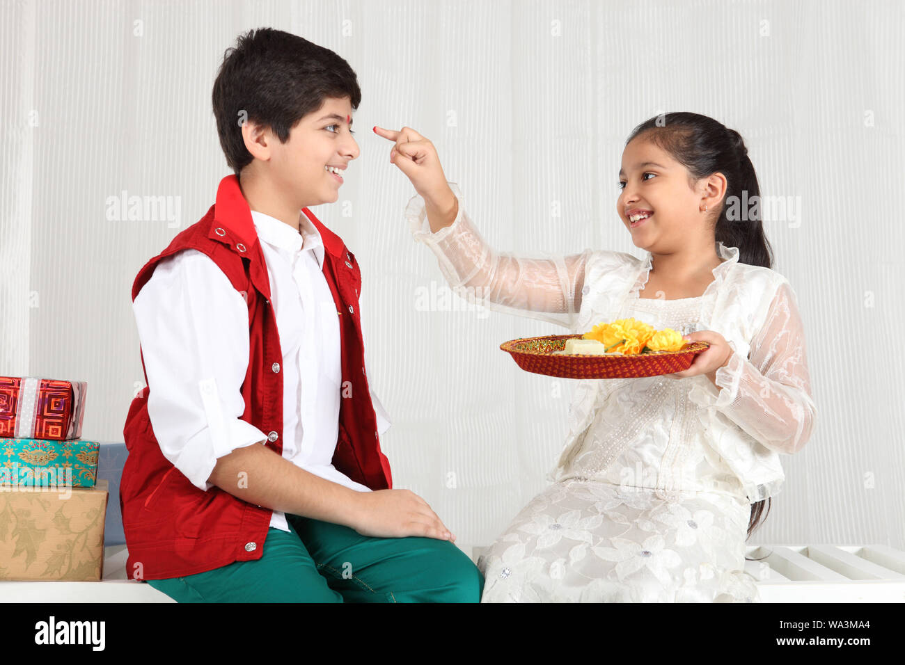 Girl applying tika on her brother forehead at Raksha Bandhan festival ...