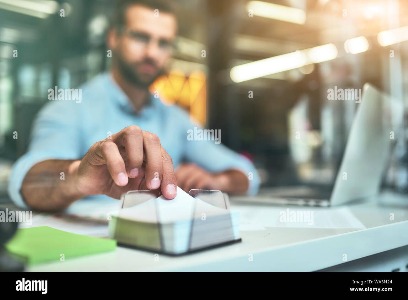 Making notes. Blurred photo of young bearded businessman taking white ...