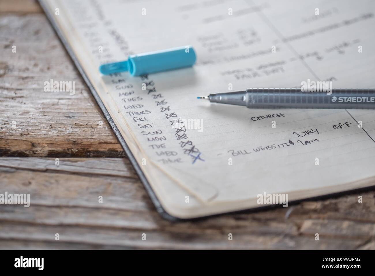 Closeup shot of an opened textbook with different dates and plans ...