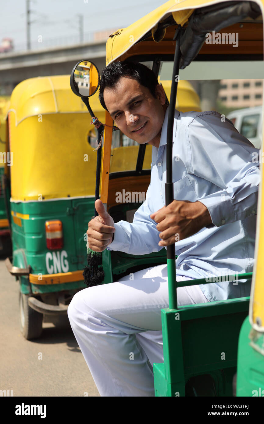 Auto driver sitting in an auto rickshaw and showing thumbs up sign ...