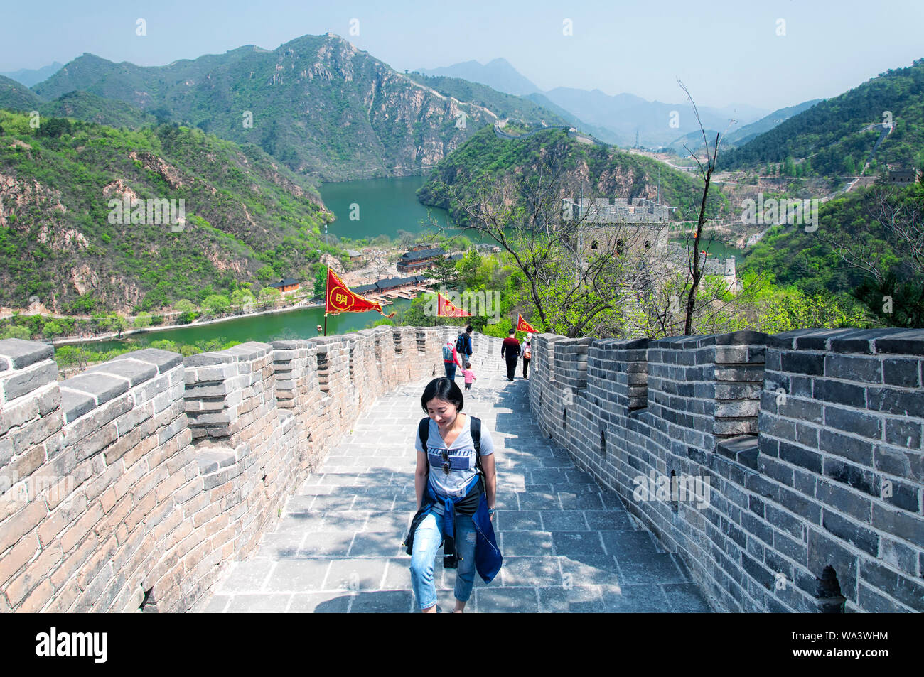 A chinese woman walking up the stone steps on the great wall of china ...