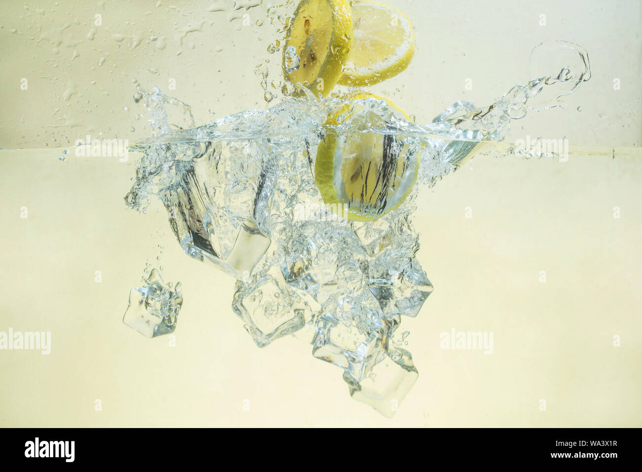 Lemon and ice fell into the water Stock Photo - Alamy