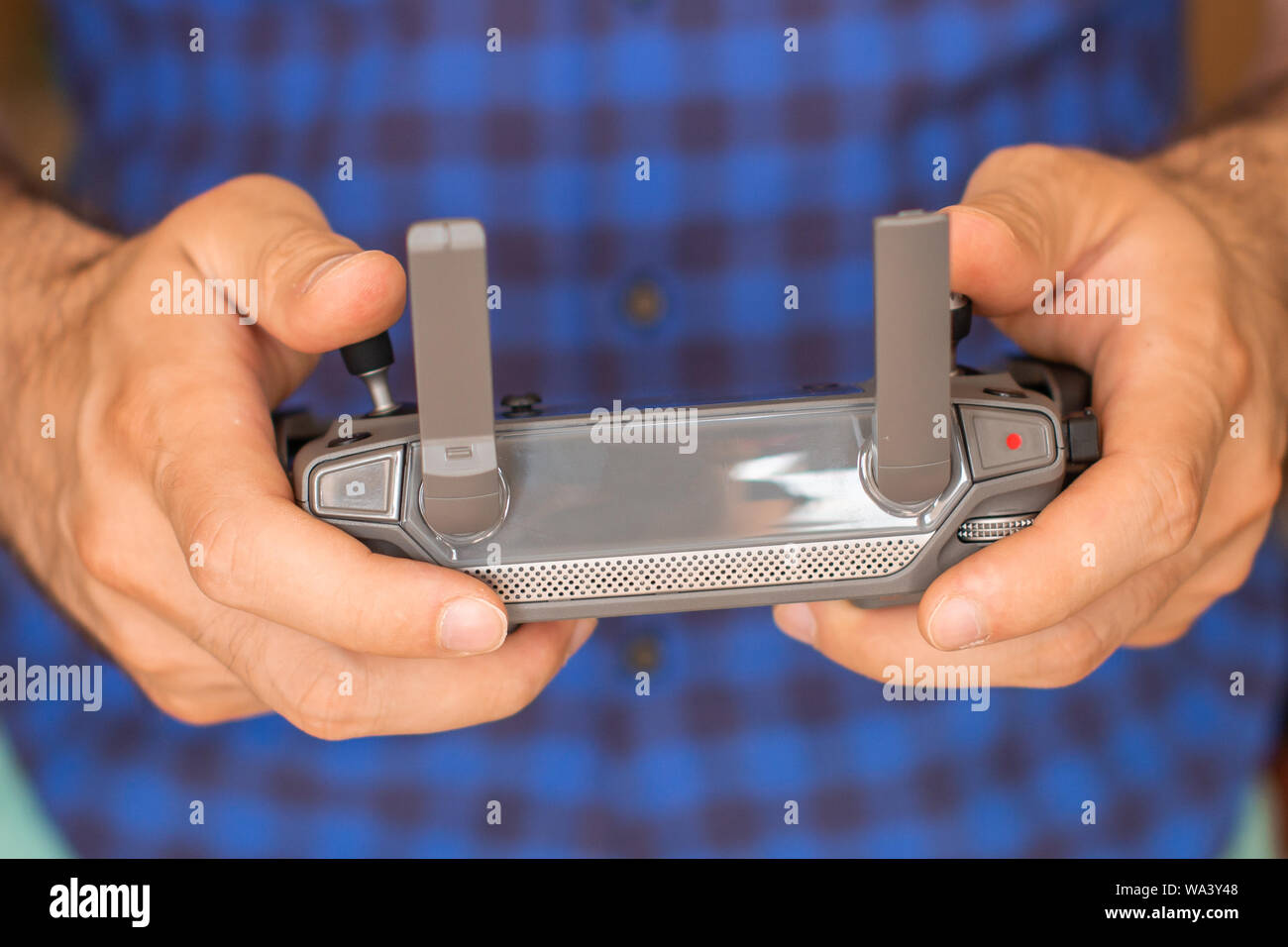 Hands with remote controller of drone outside. Man using RC for flying ...