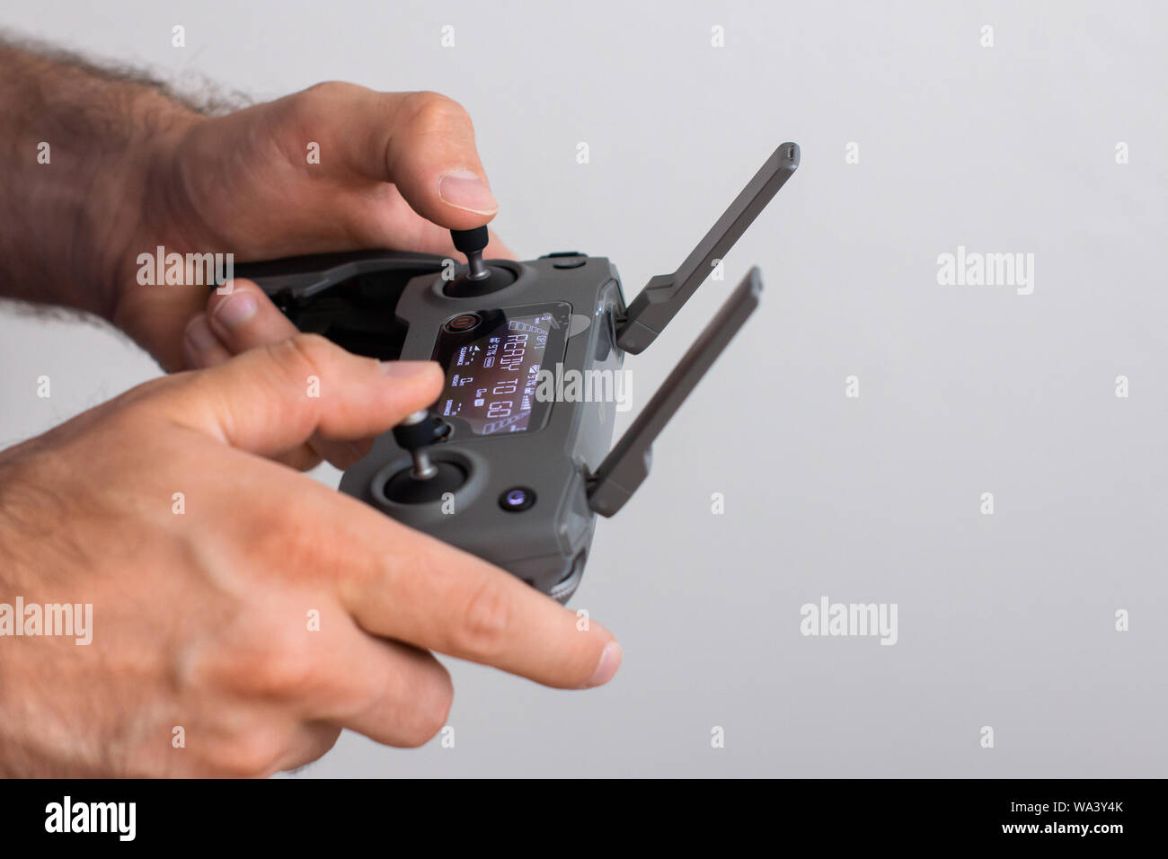 Hands with remote controller of drone outside. Man using RC for flying ...