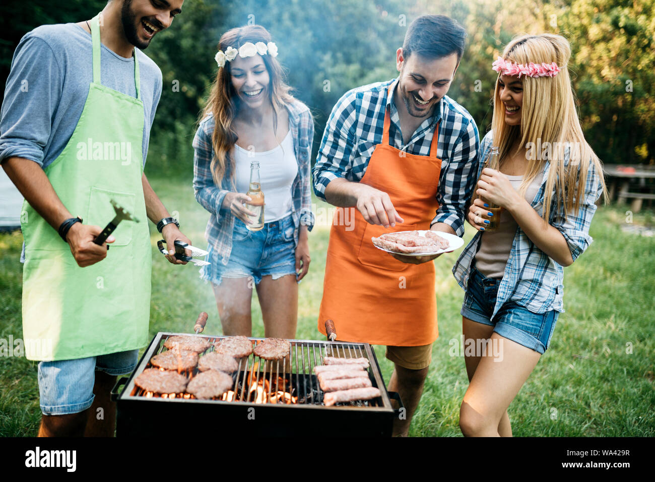 Group of happy friends having outdoor barbecue laughing together Stock ...