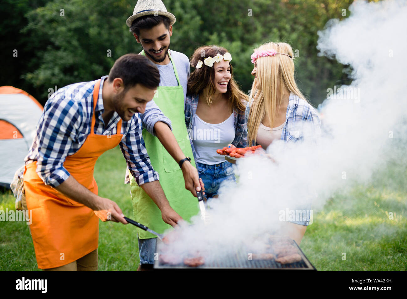 Group of friends making barbecue in the nature Stock Photo - Alamy