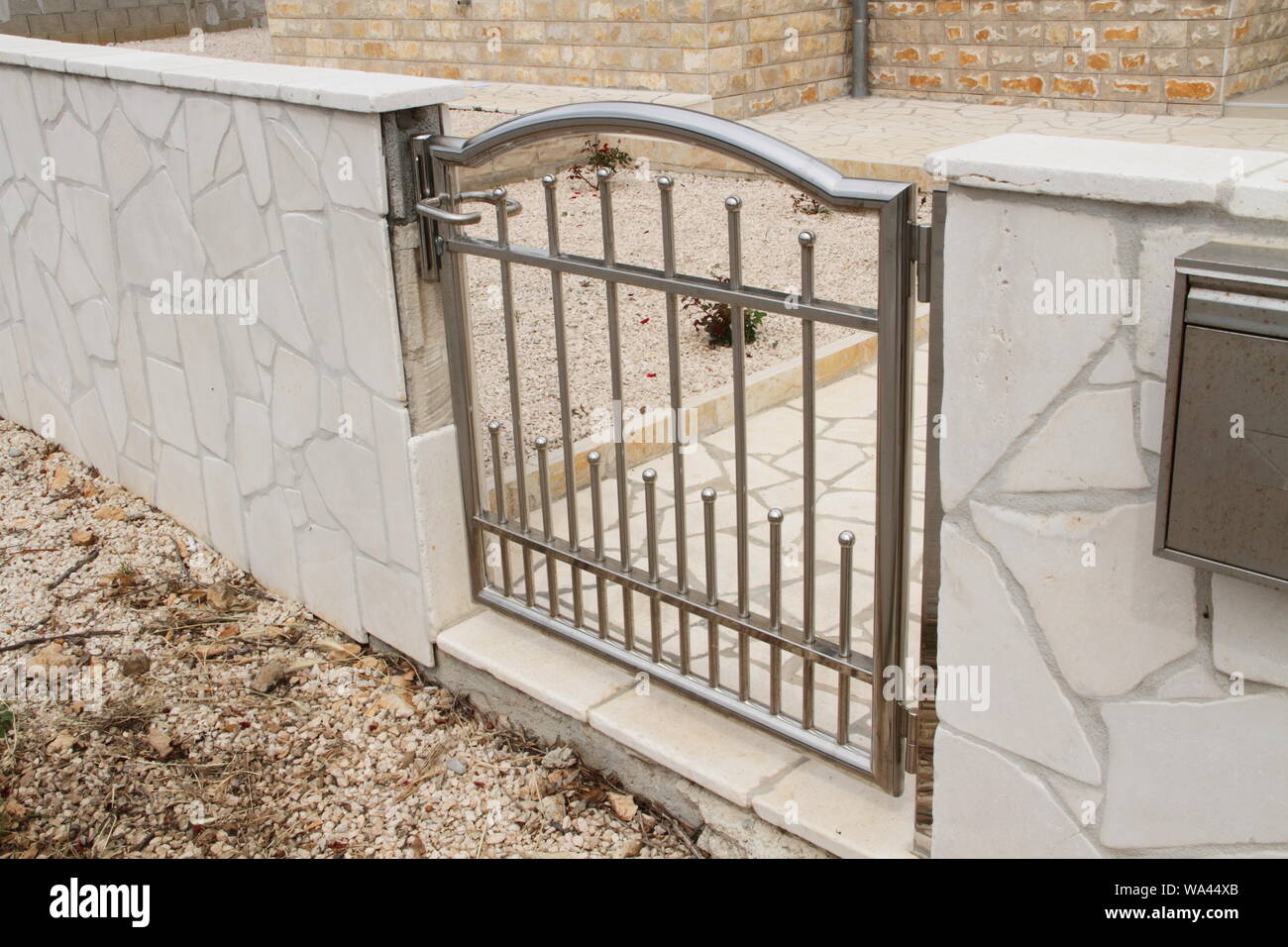 a new house with a metal sliding gate Stock Photo - Alamy