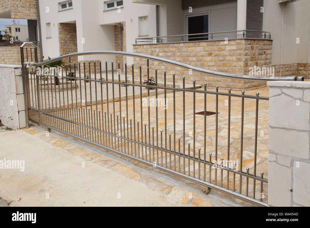a new house with a metal sliding gate Stock Photo - Alamy