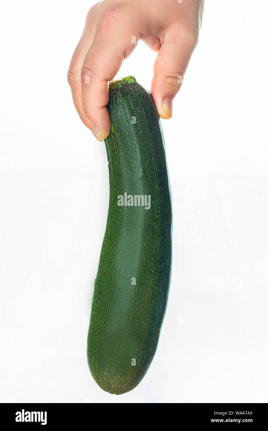 Hand with zucchini on a white background. Woman with zucchini in hand ...