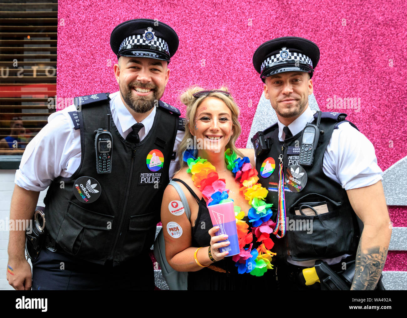 Two Metropolitan Policemen pose with a reveller at Pride in London ...