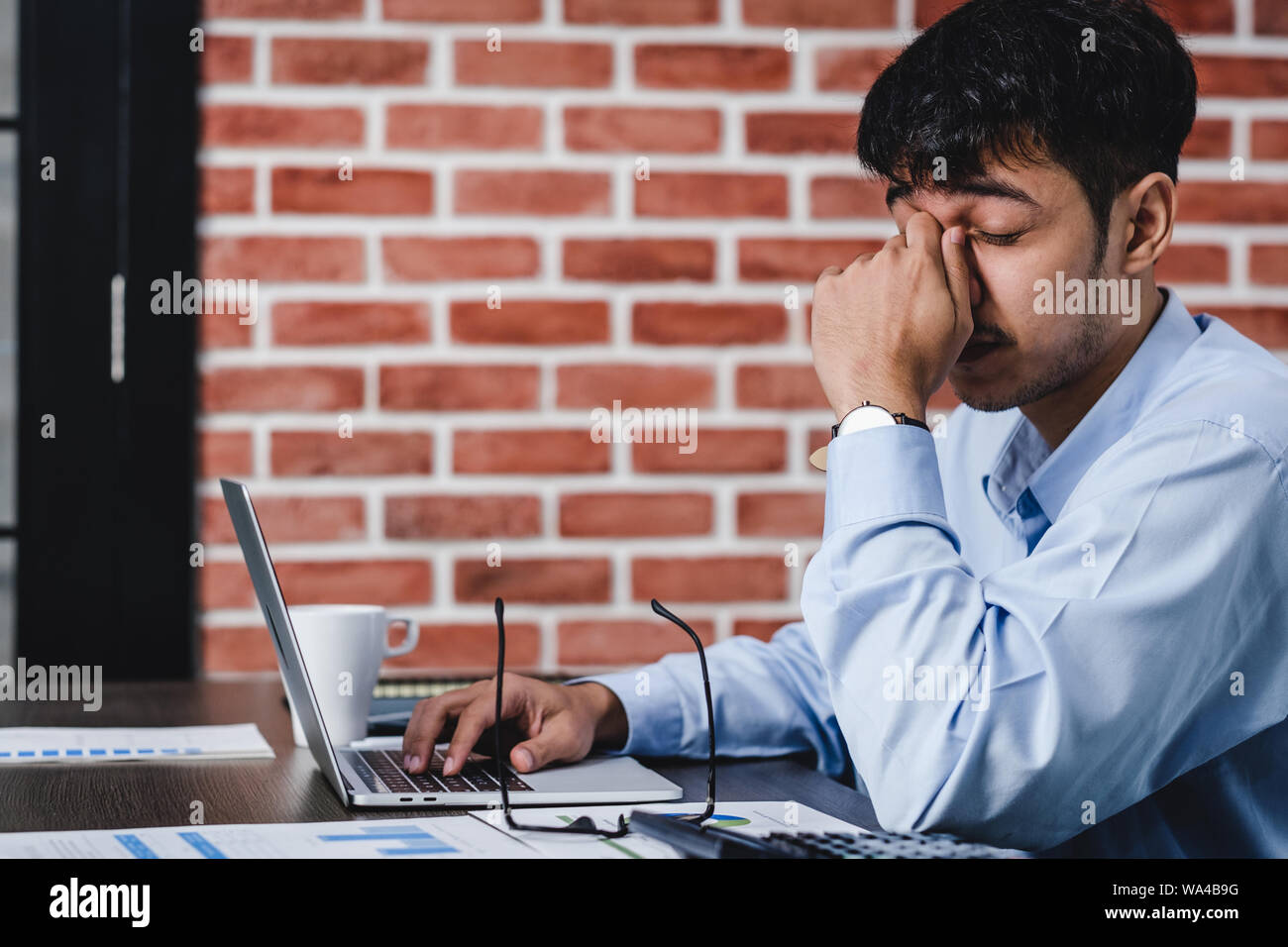 asian businessman get stress and headache when working with laptop on ...