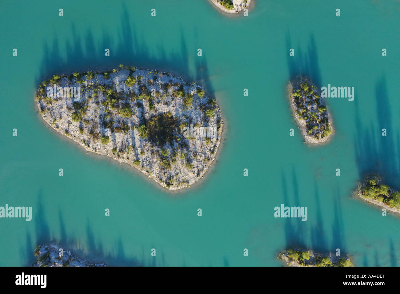 Islands in an azure quarry pond pit with trees Stock Photo - Alamy
