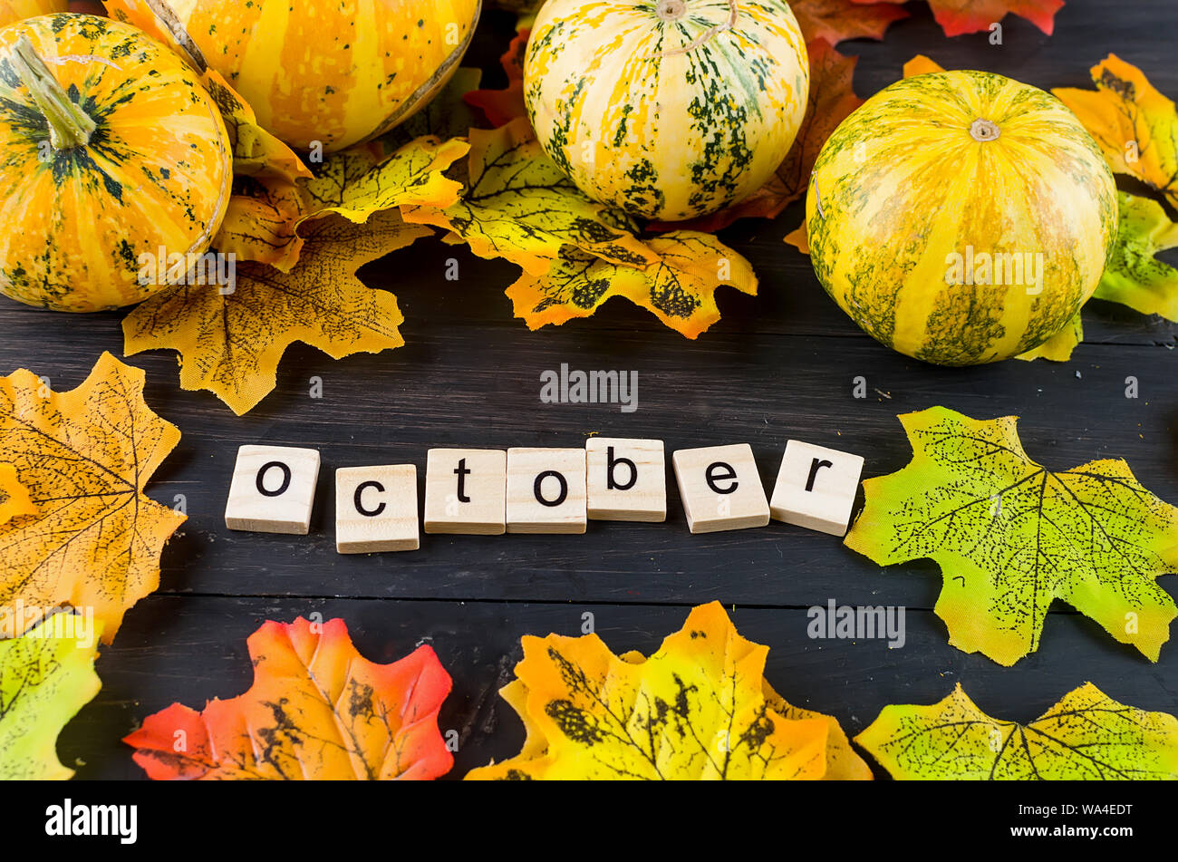 Autumn background with decorative pumpkins, leaves and text "october ...