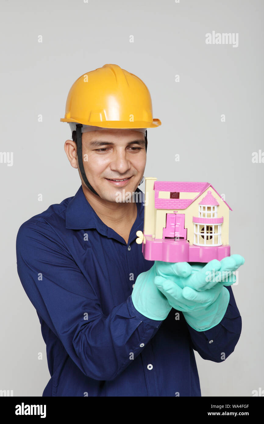 Plumber showing model of dream home Stock Photo - Alamy
