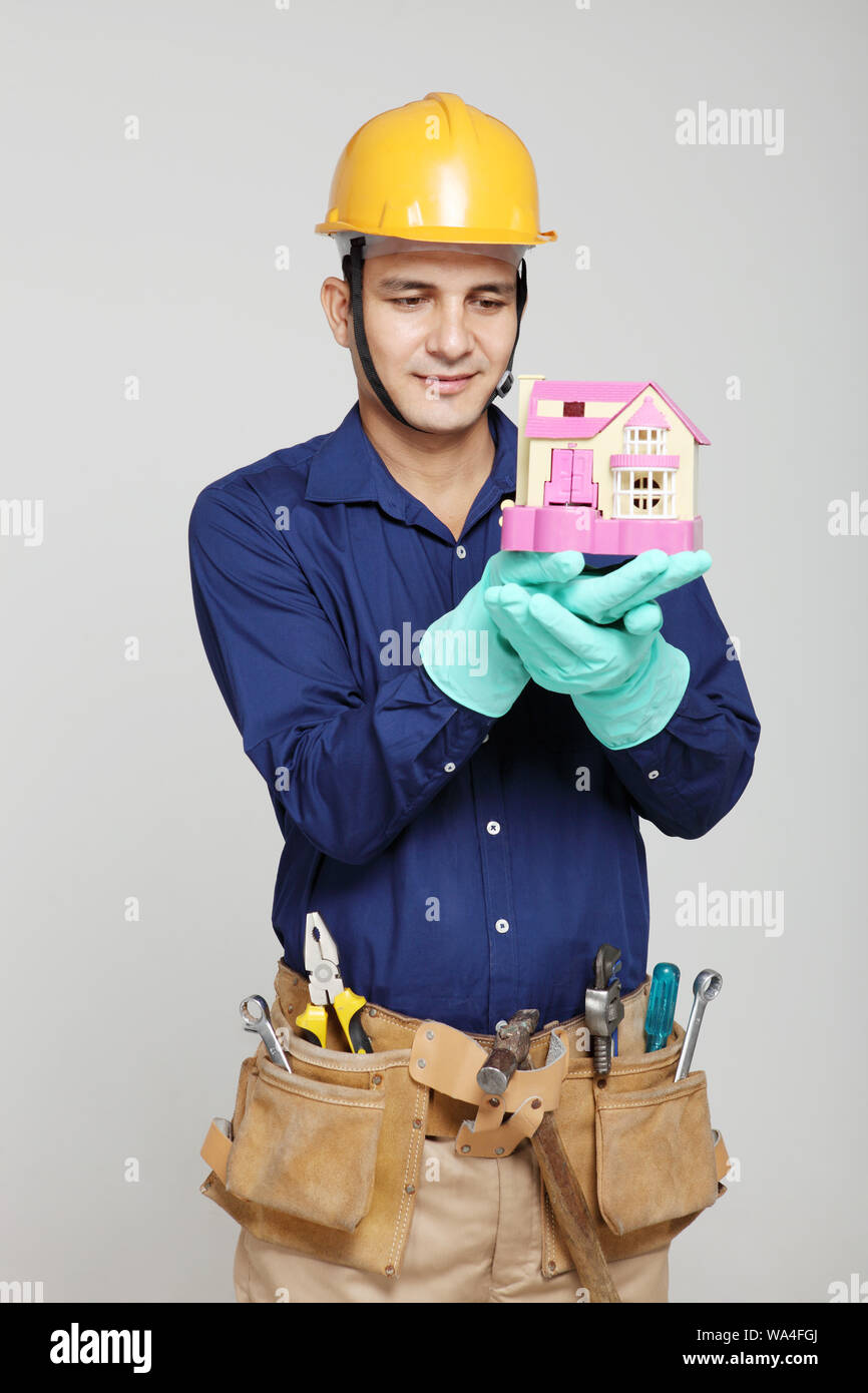Plumber showing model of dream home Stock Photo - Alamy