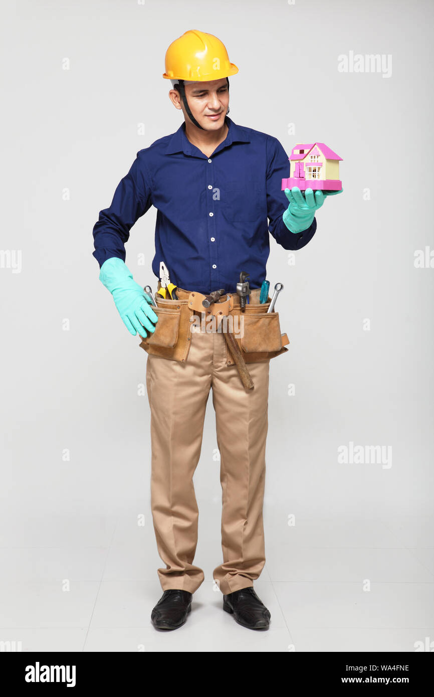 Plumber showing model of dream home Stock Photo - Alamy