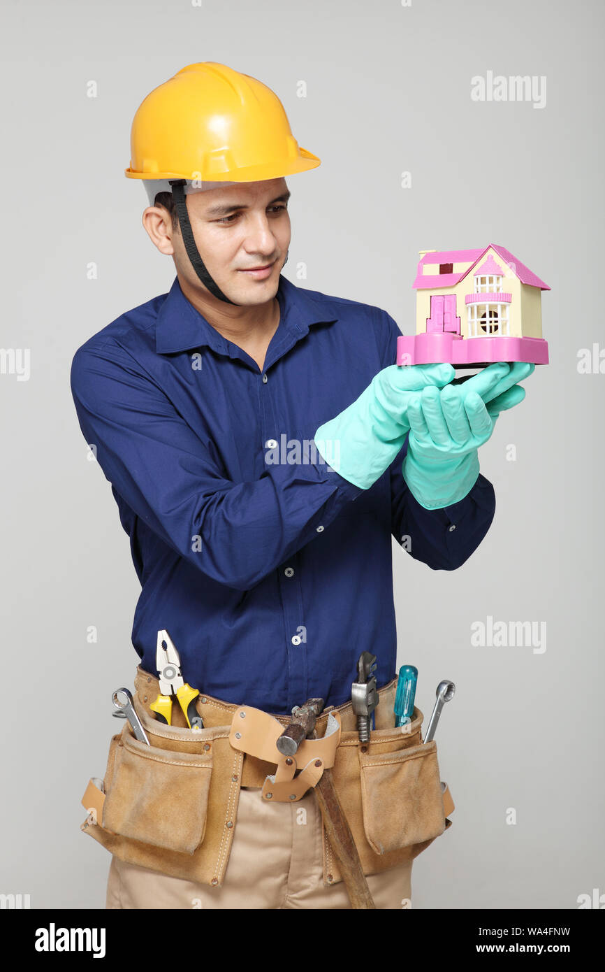 Plumber showing model of dream home Stock Photo - Alamy