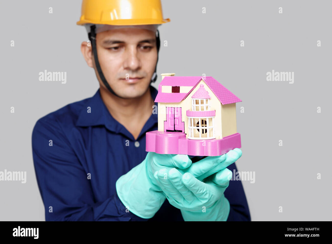 Plumber showing model of dream home Stock Photo - Alamy