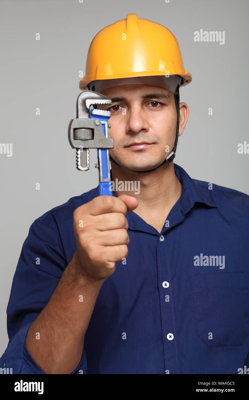 Plumber showing an adjustable wrench Stock Photo - Alamy