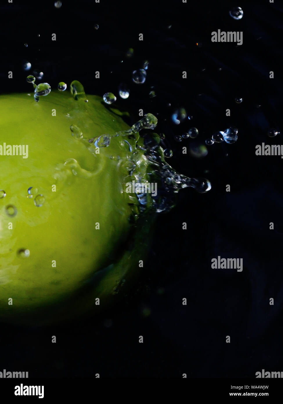 Green apple dropped into water splash Stock Photo - Alamy