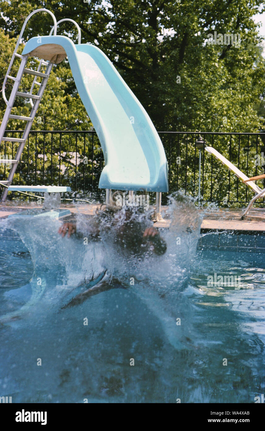 1977 - Young teen uses a pool slide in a residential swimming pool to ...