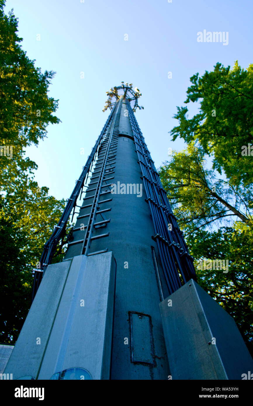 Telecommunication mast and green trees at the blue sky Stock Photo - Alamy