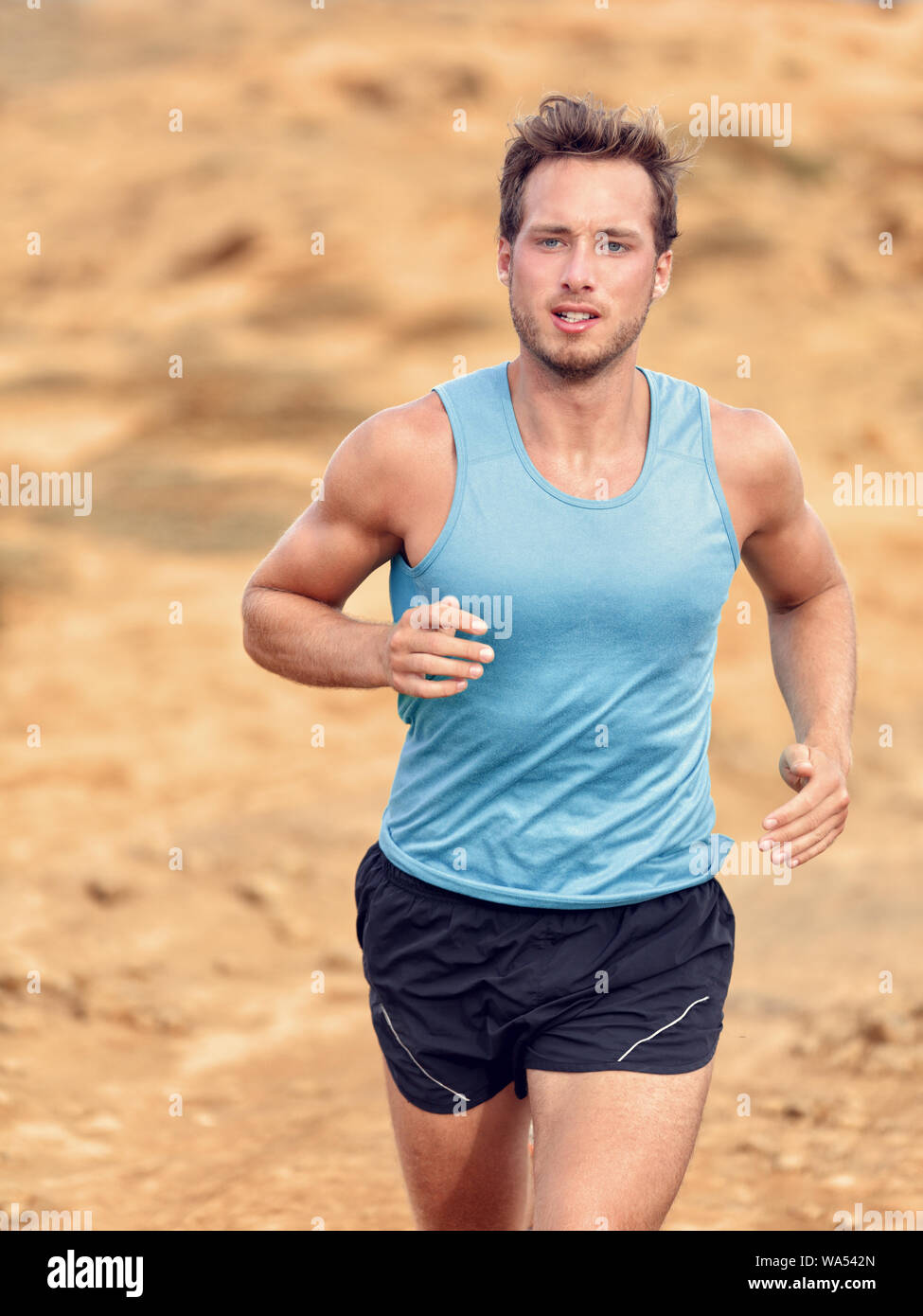 Trail runner training cardio running on rocky mountains yellow sand ...