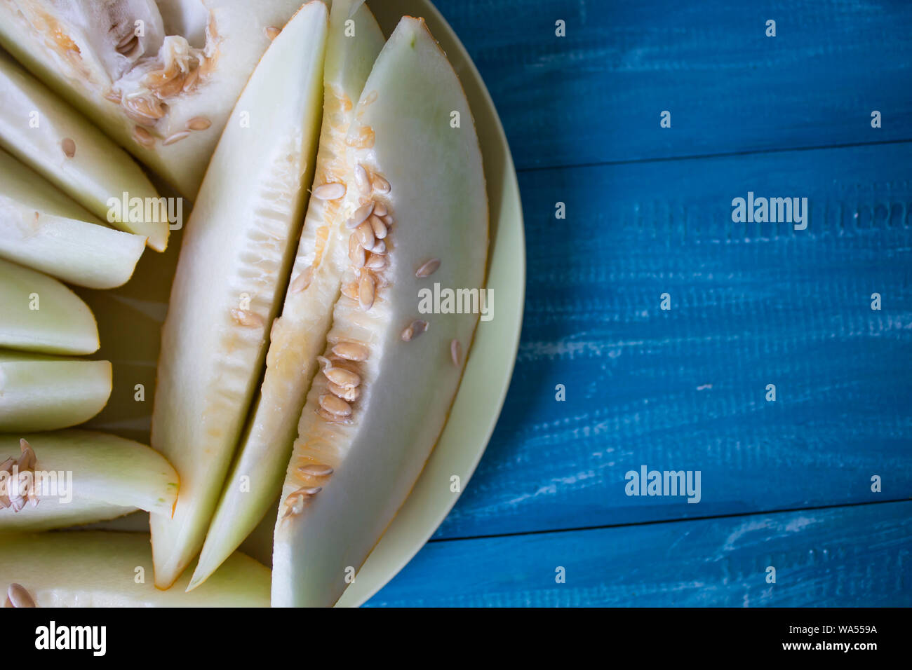 top view of a melon. melon decorated with slices against a blue ...