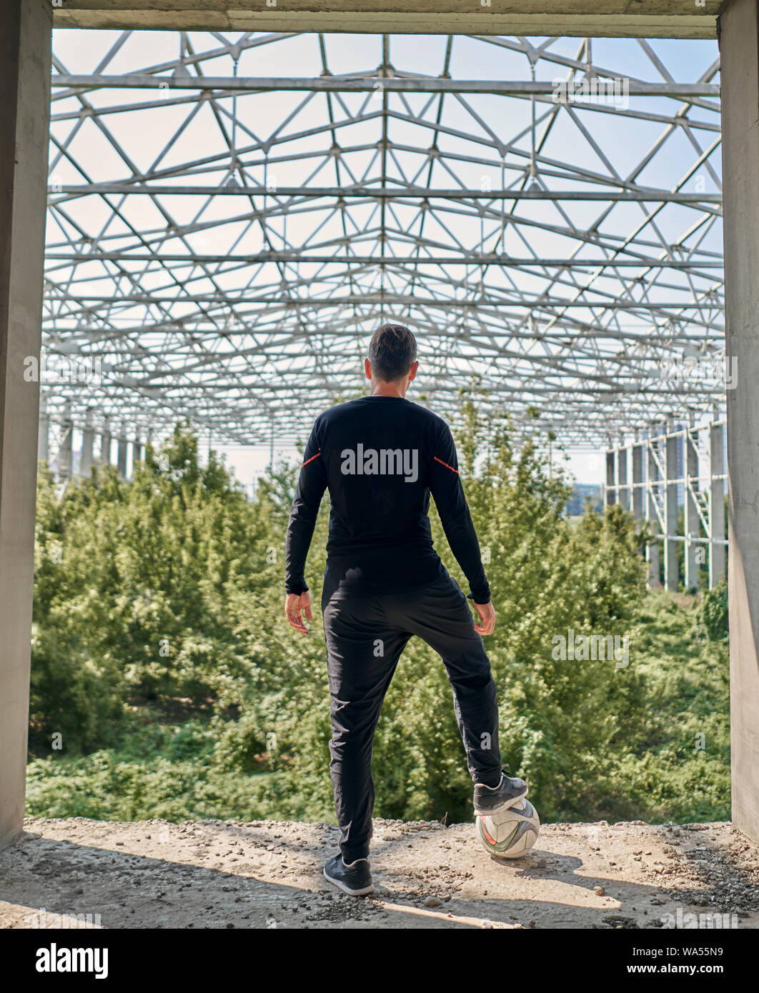 football player with the ball at the building Stock Photo - Alamy