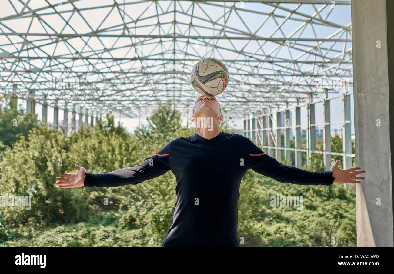 football player with the ball at the building Stock Photo - Alamy