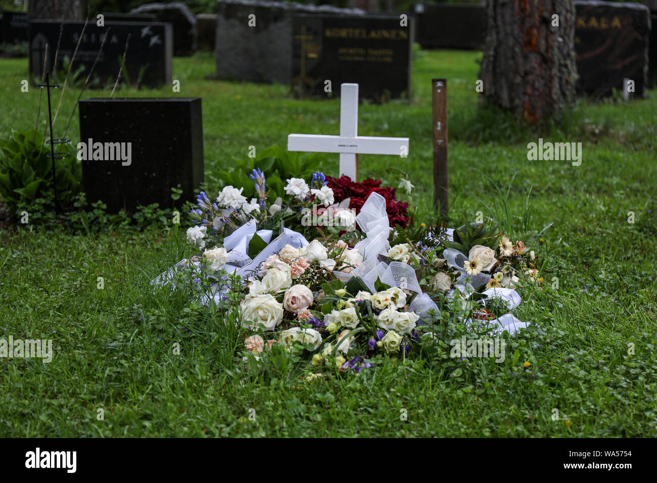 Fresh grave covered with funeral flowers Stock Photo - Alamy