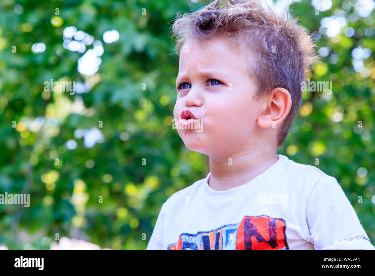 Toddler making faces in Park Stock Photo - Alamy