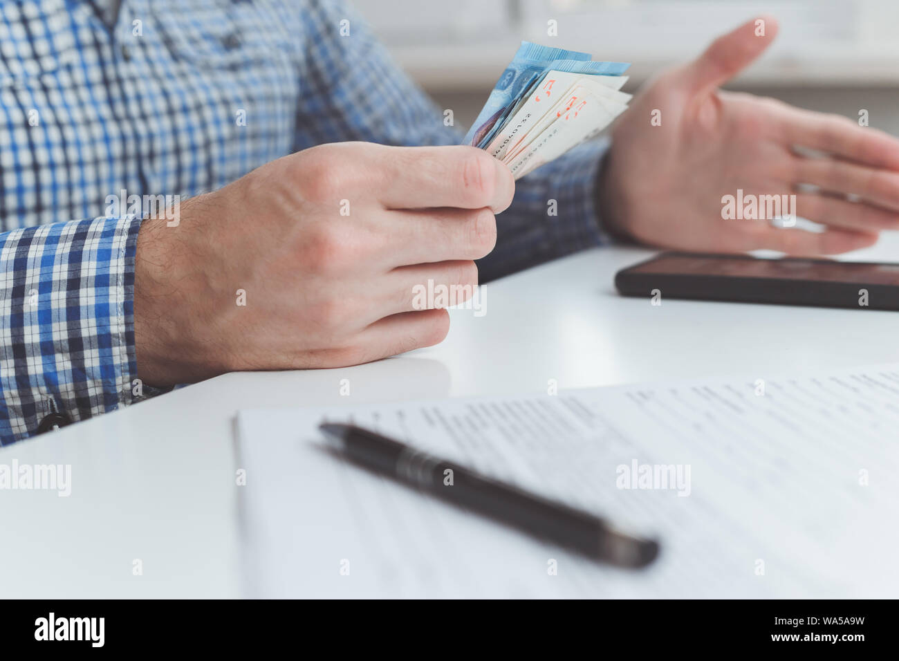 Tough financial conditions. Businessman holds money and gestures ...