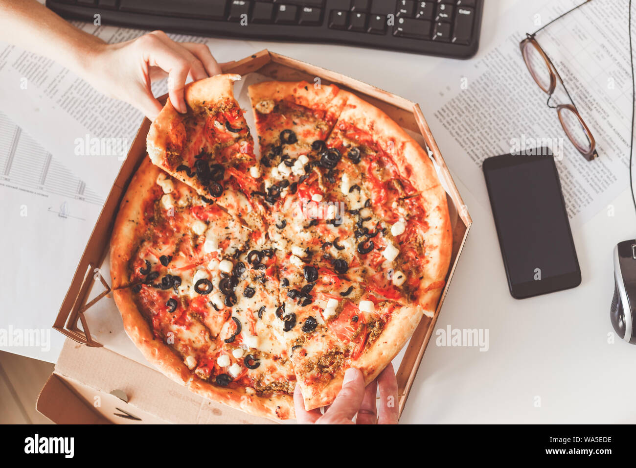 Business lunch at the workplace. Vegetarian pizza sharing Stock Photo ...