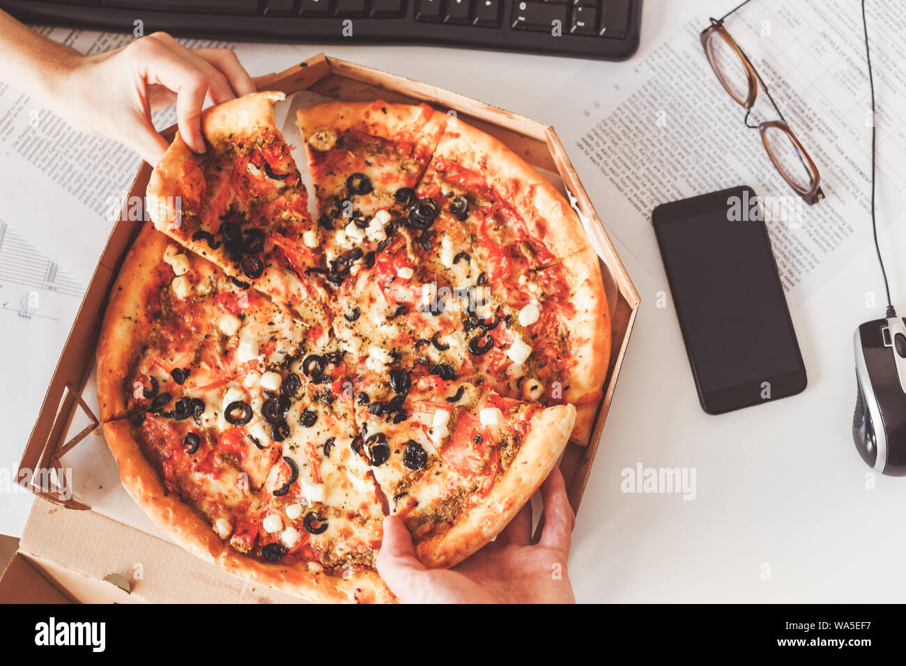 Business lunch at the workplace. Vegetarian pizza sharing Stock Photo ...