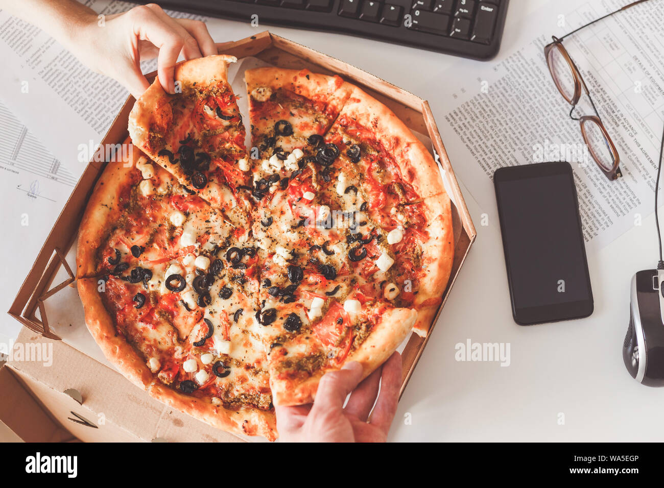 Business lunch at the workplace. Vegetarian pizza sharing Stock Photo ...