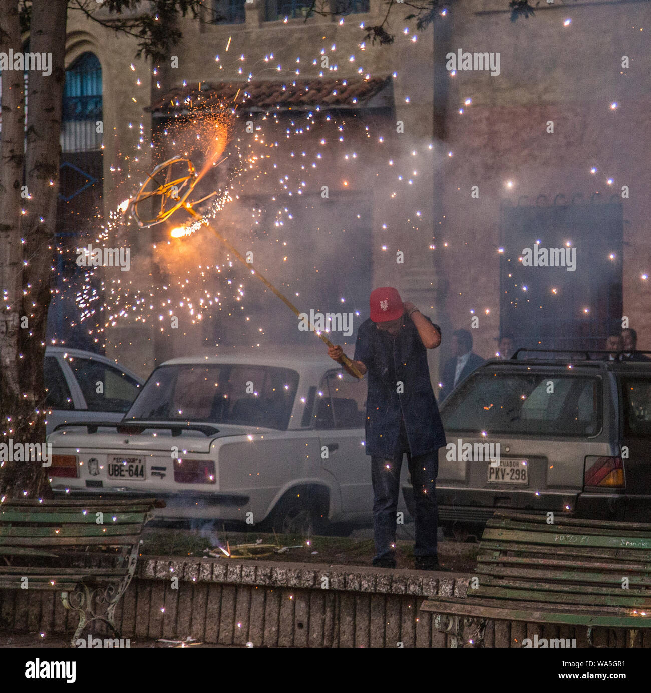 Cuenca, Ecuador - Nov 29, 2012: Man holds fireworks pinwheel at the end ...