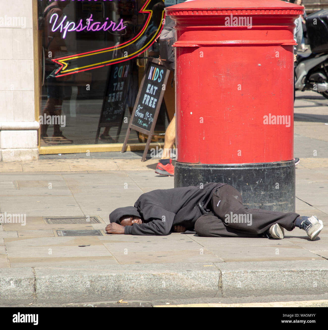 Homeless man lays on the street near Piccadilly Circus in London on a ...