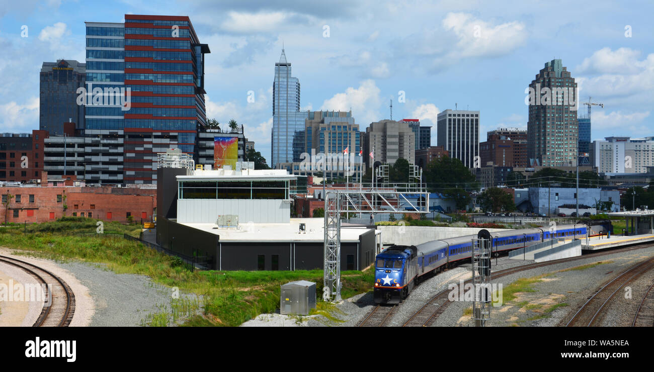 An Amtrak train leaves the Raleigh station with the skyline in the ...