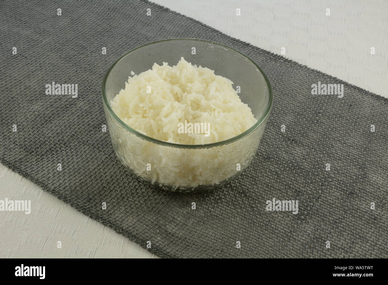 Warm steamed white rice in glass bowl with condensation from heat ...