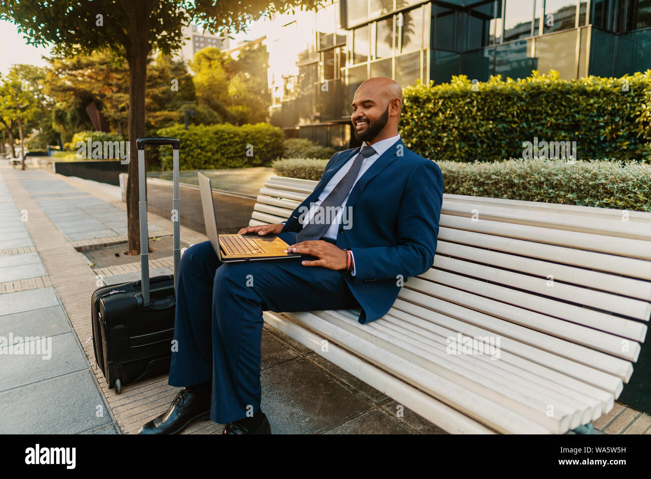 Indian businessman holding laptop notebook wearing blue suit near ...