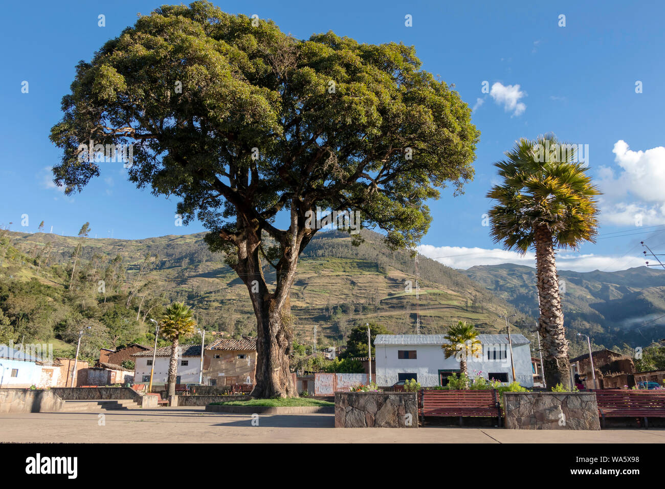 The main square of Cachora village with snow Andes mountains on the ...