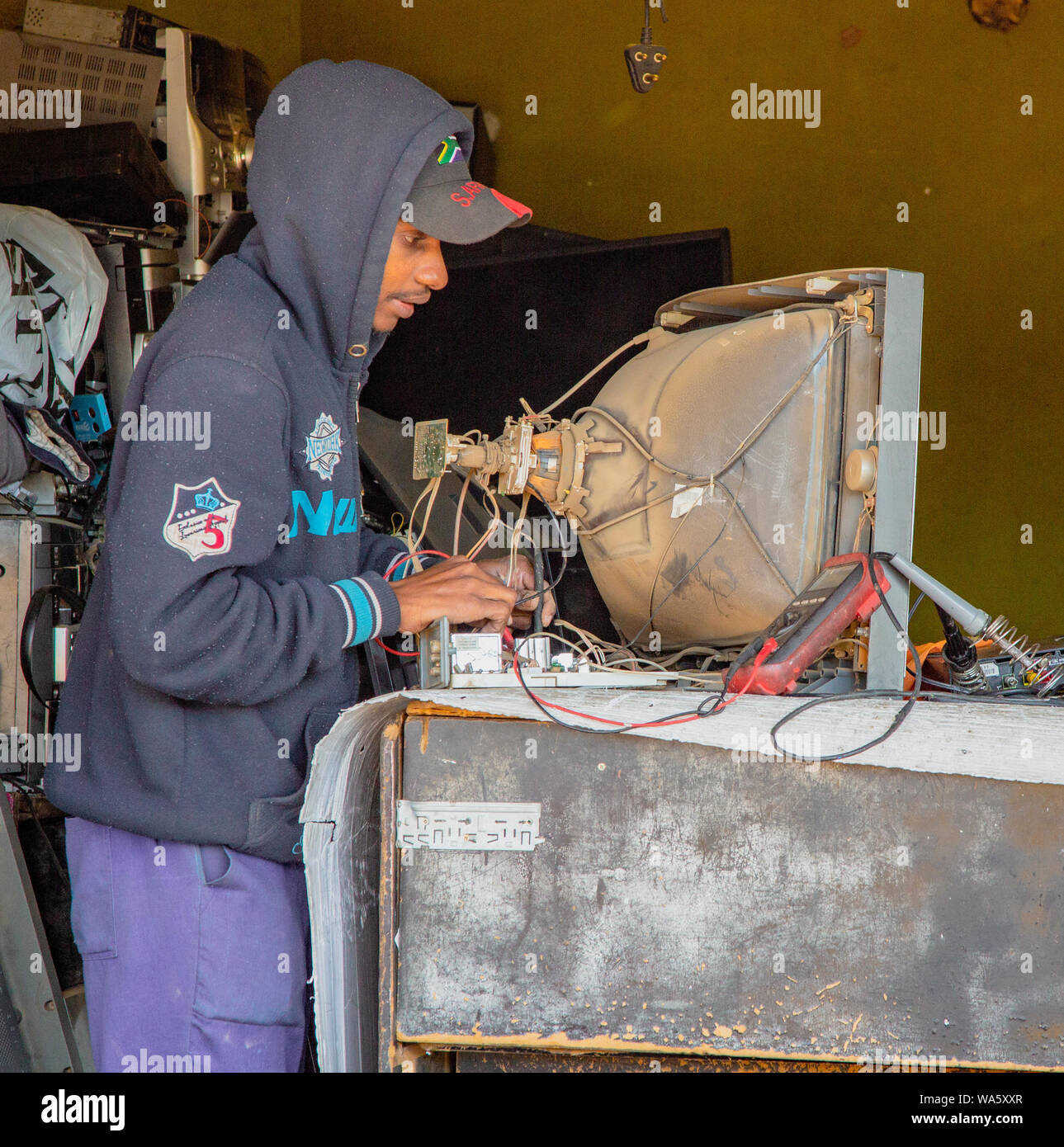 Windhoek, South Africa - July 6, 2018: A man repairs old CRT ...