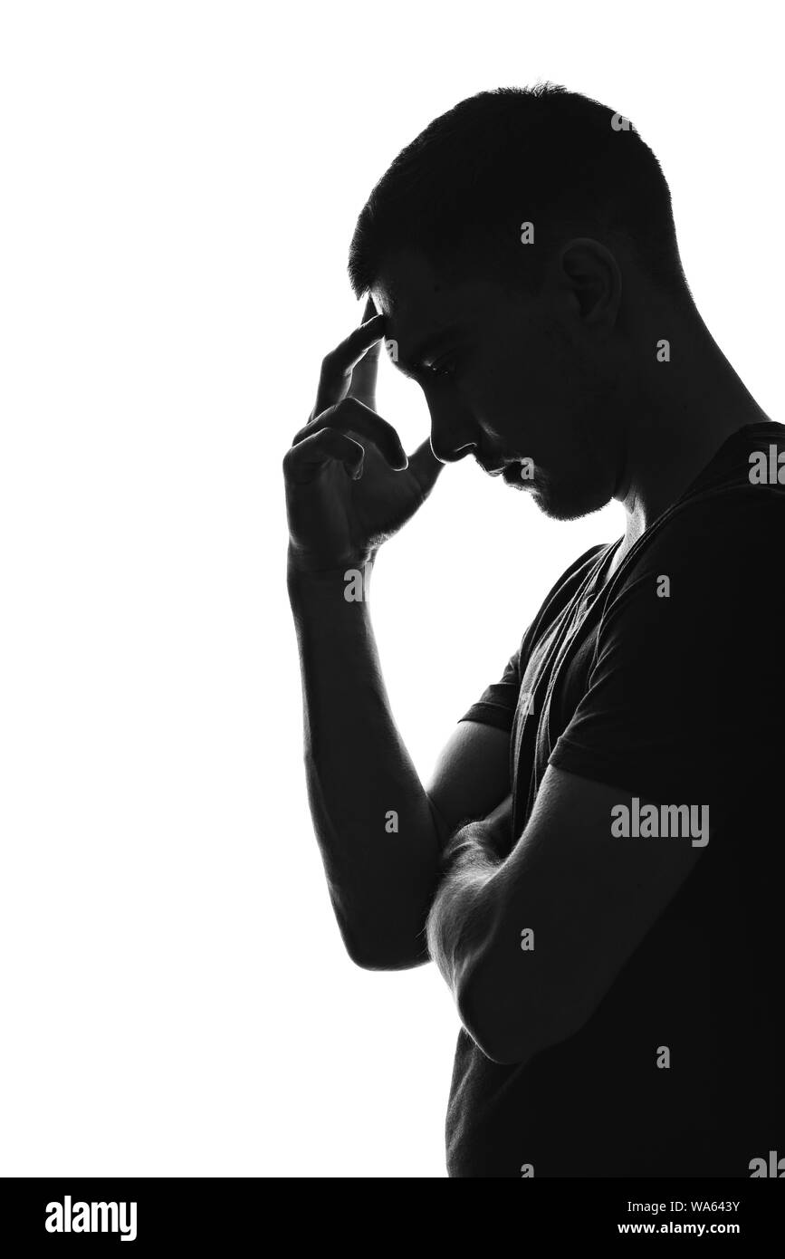 vertical Silhouette portrait profile of thinking young man holding his ...