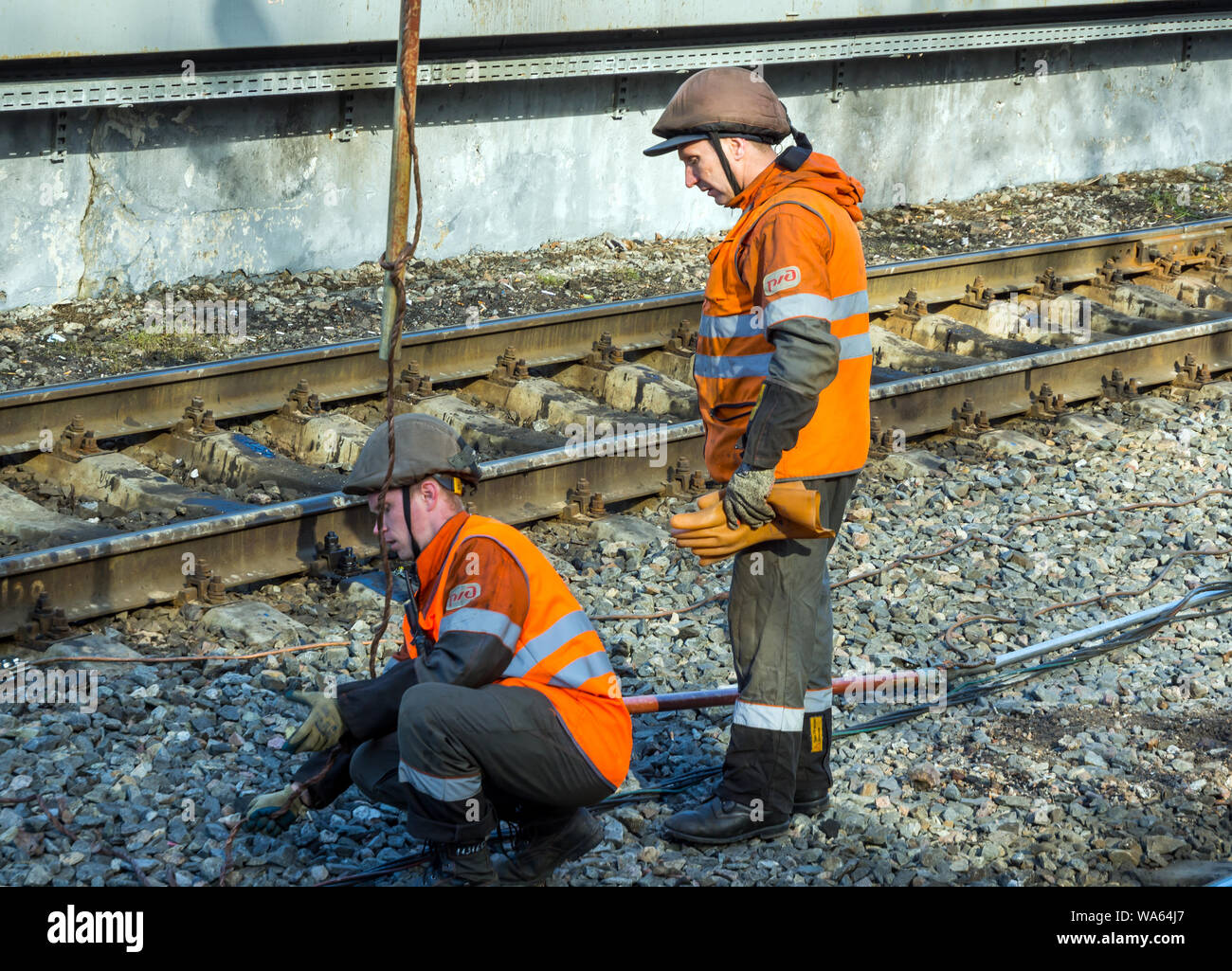Murmansk, Russia - April 22, 2019: Railway workers connect ground wire ...