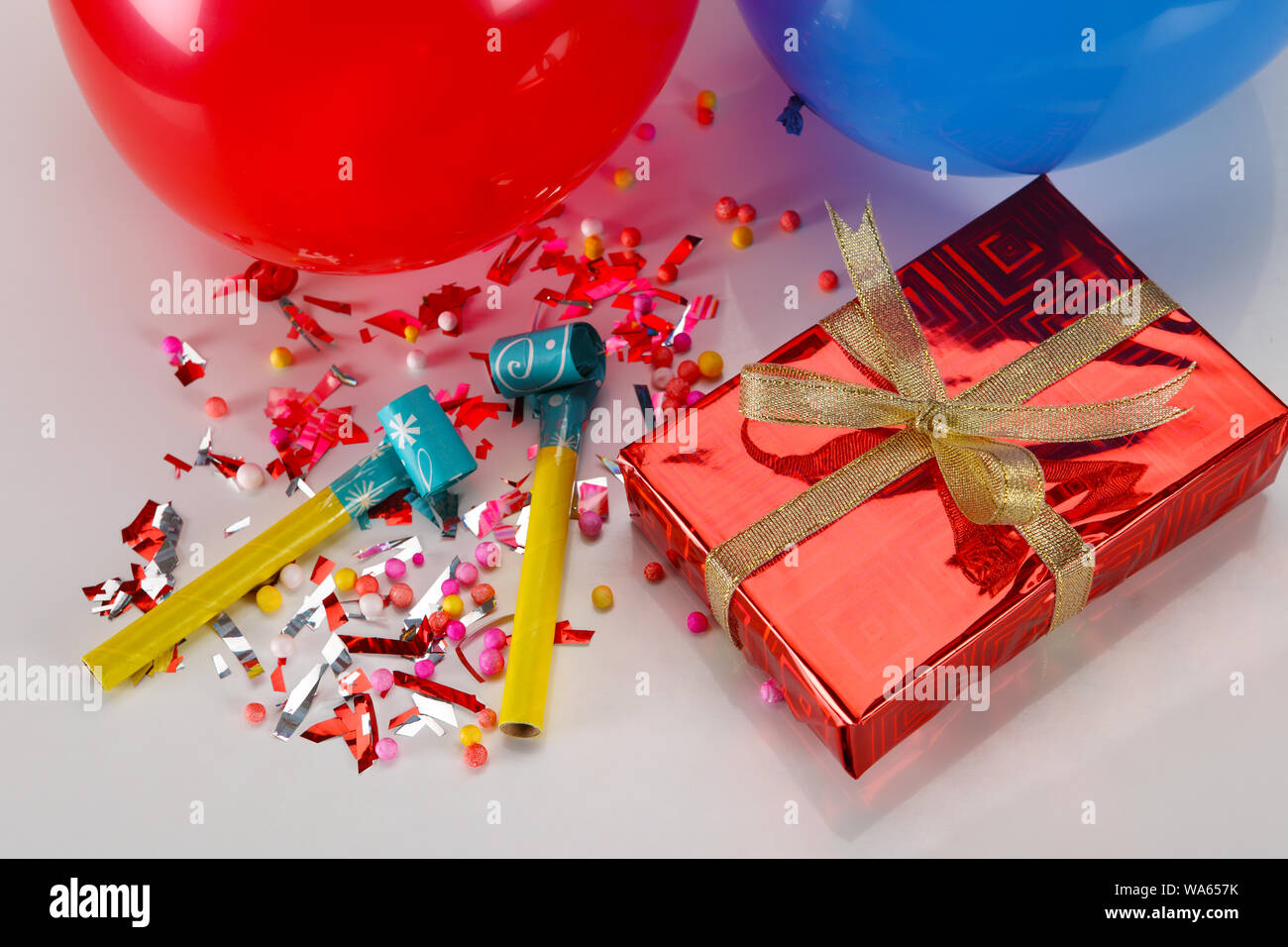 Gift box with balloons and party blowers Stock Photo - Alamy
