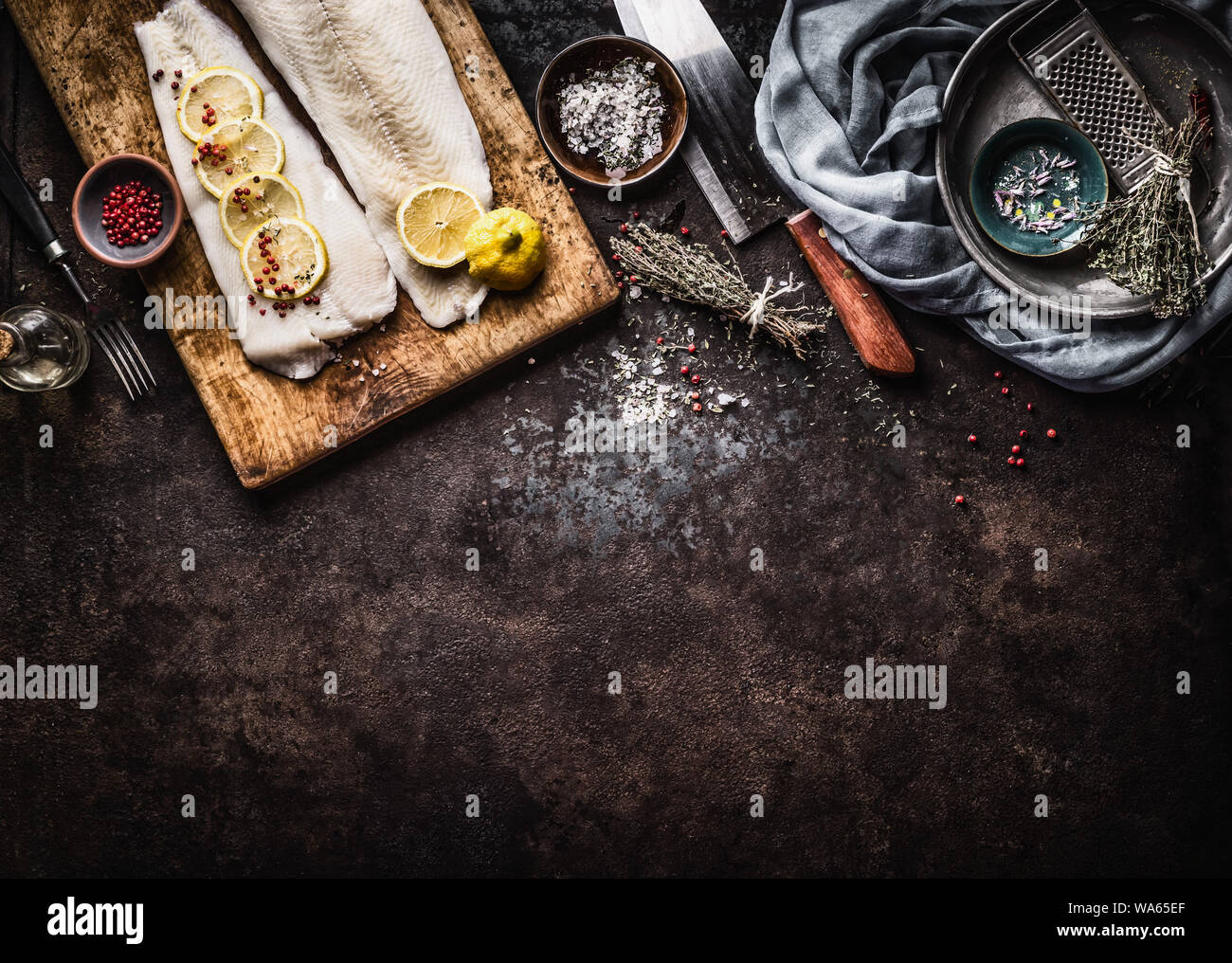 Food background with raw cod fillet with lemon slices and herbs on ...