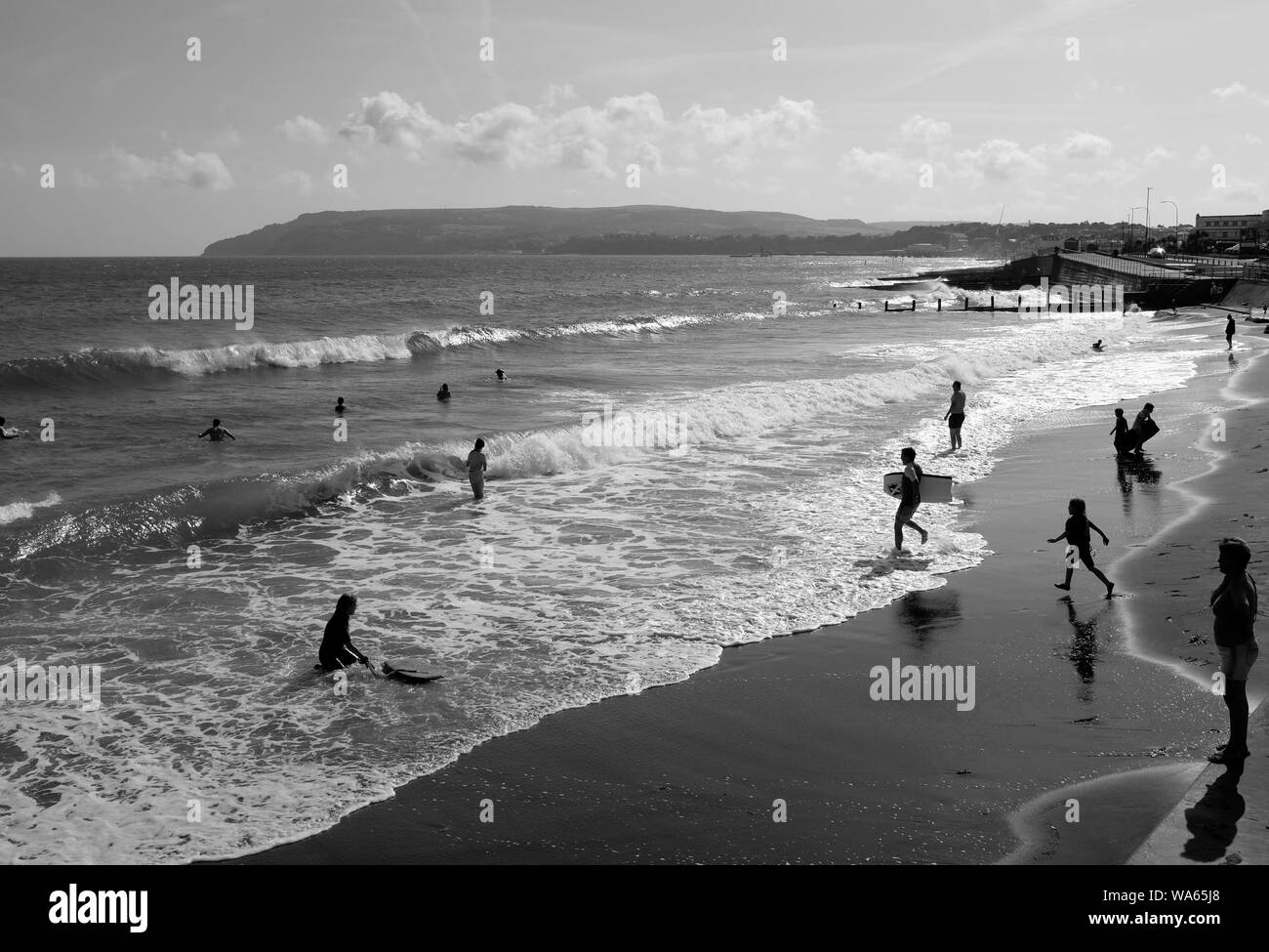 Beachgoers enjoying playing in the surf at the beach Stock Photo - Alamy